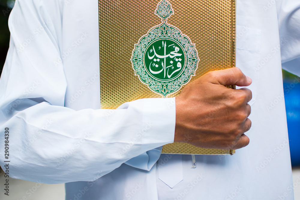 gold Holy Quran in hand arab man.concept for Ramadan, Eid al Fitr, eid ...