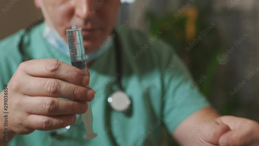 Experienced doctor getting a new syringe ready for an injection ...