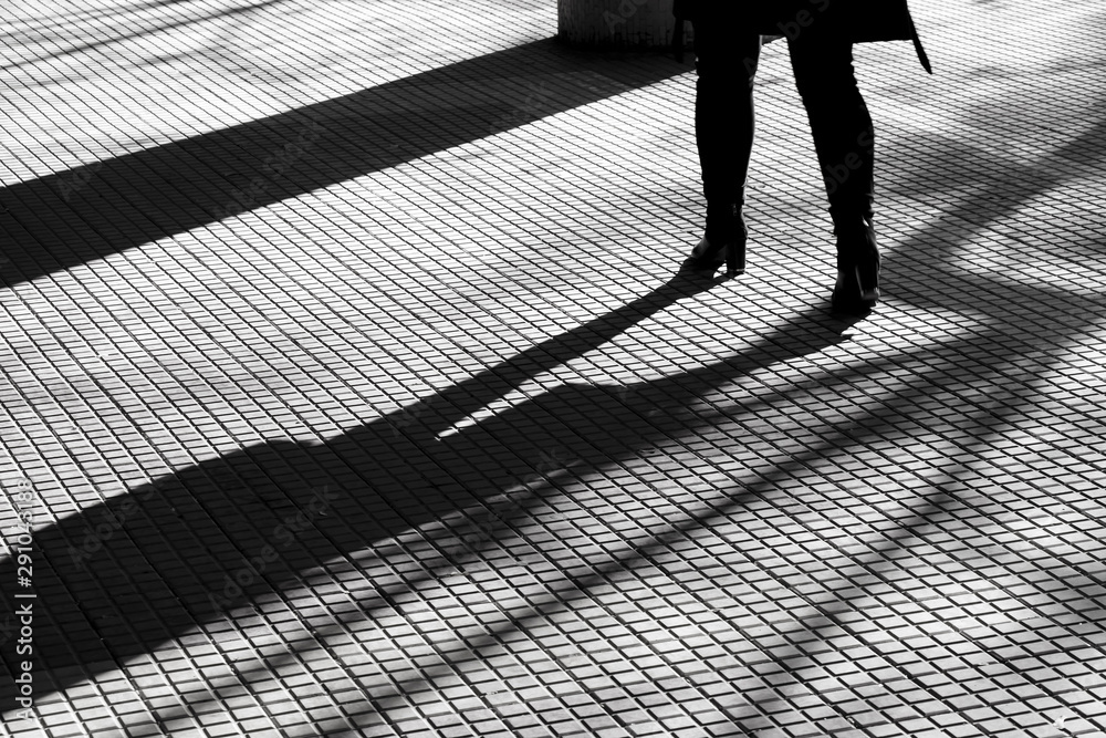 Blurry silhouette shadow of legs of a woman in high heels walking alone ...