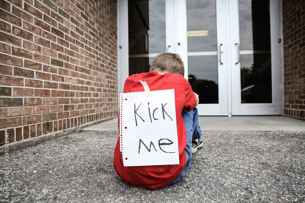 Sad boy with a kick me sign taped to his back, bullying Stock Photo ...