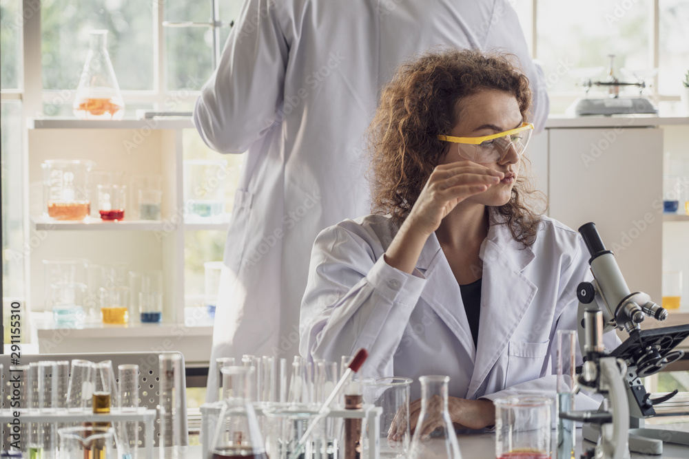 Foto de Team of Medical Research Scientist Conducts Experiments in Laboratory with Microscope ...