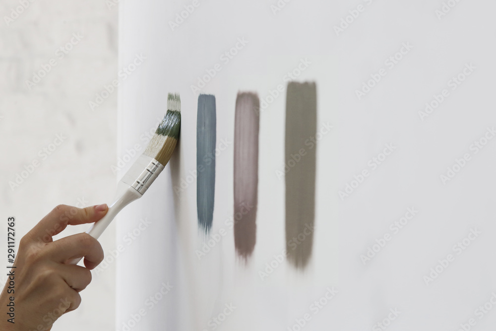 A different color swatches on the white wall. Process of choosing the ...