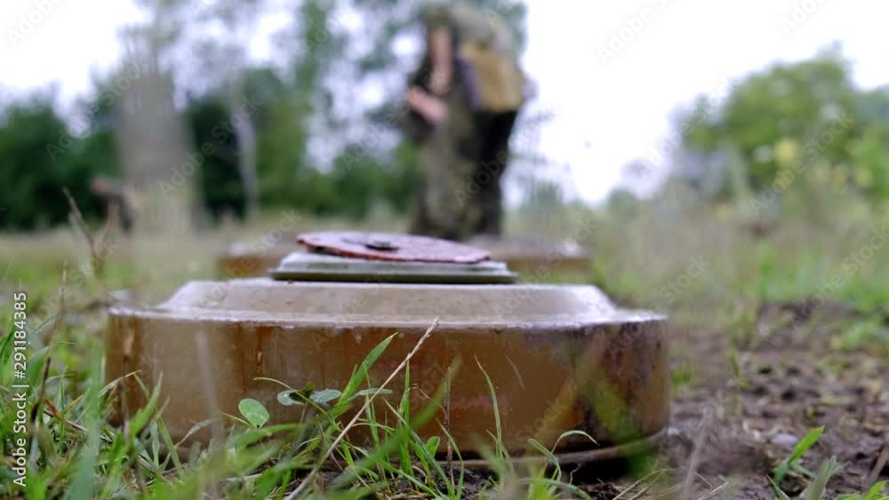 Several military cadets of soldiers dig a hole to bury three anti-tank ...