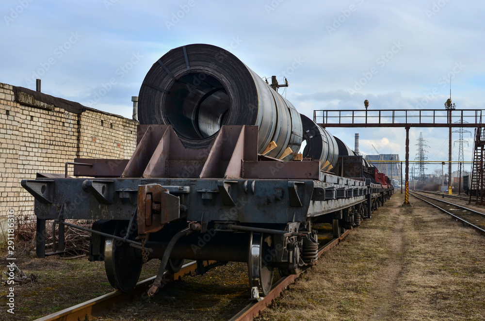 Rolled steel coil on a rail platform fixed by a chain. Transportation ...