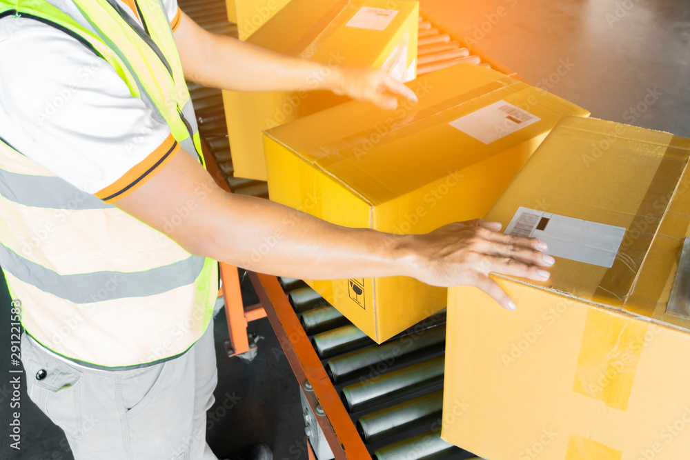 warehouse worker sorting parcels packaging boxes on conveyor belt at ...