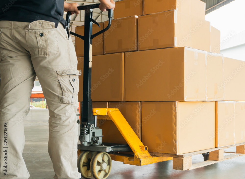 Workers using Hand Pallet Jack Unloading Packaging Boxes. Commerce ...