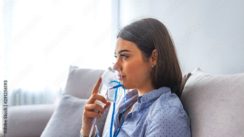 Use nebulizer and inhaler for the treatment. Young woman inhaling ...