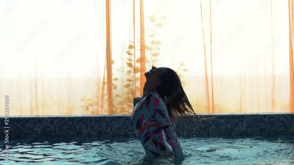 Girl with a beautiful body in a colored swimsuit underwater in the pool ...