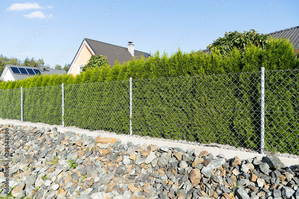 Street fence made of steel mesh, concrete is installed, pebble stones ...