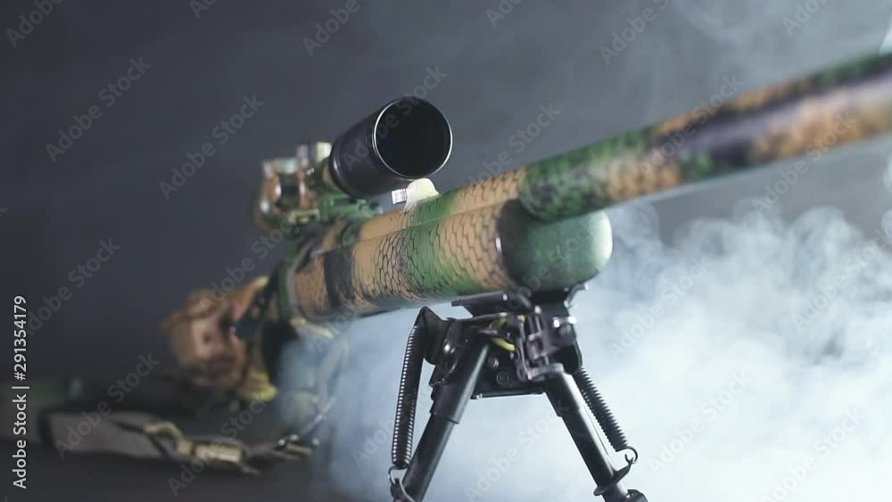 Slow plan of sniper rifle with silencer. Dark background and overhead ...