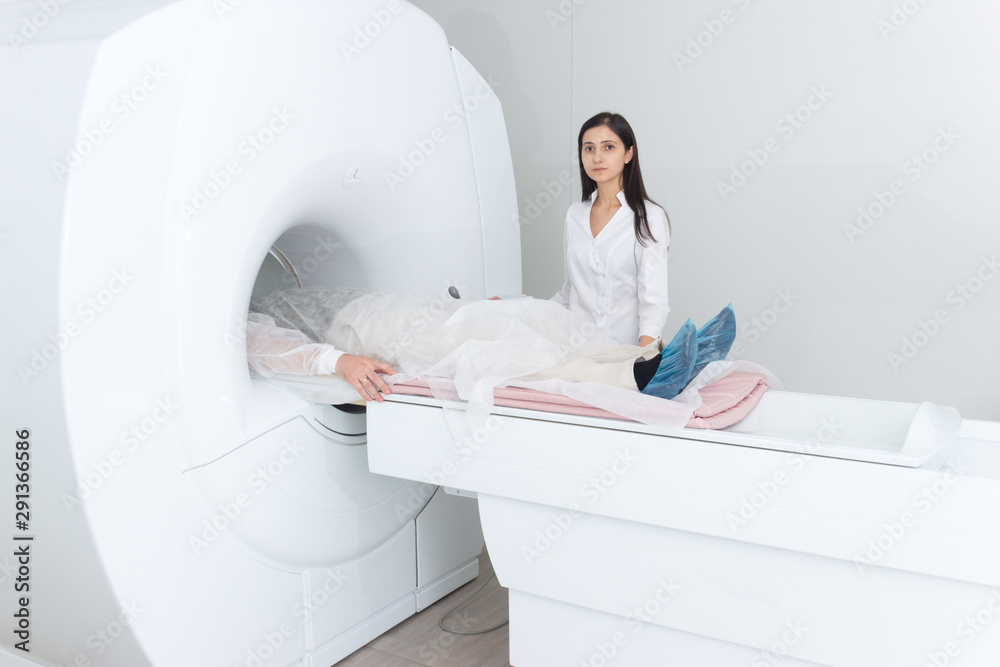 Radiologic technician and man patient lying on a CT Scan bed. preparing ...