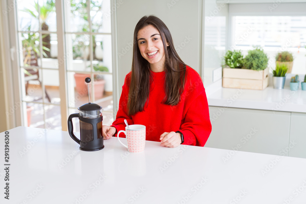Young beautiful woman making morning coffee smiling, preparing a cup of ...
