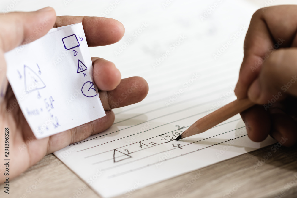 Student using formula math sheet to cheat on test. Hand of university ...