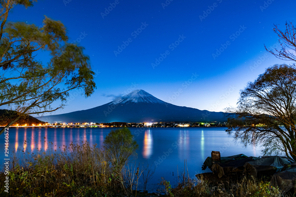Mount fuji with star in the blue sky and lgiht from the city with tree ...