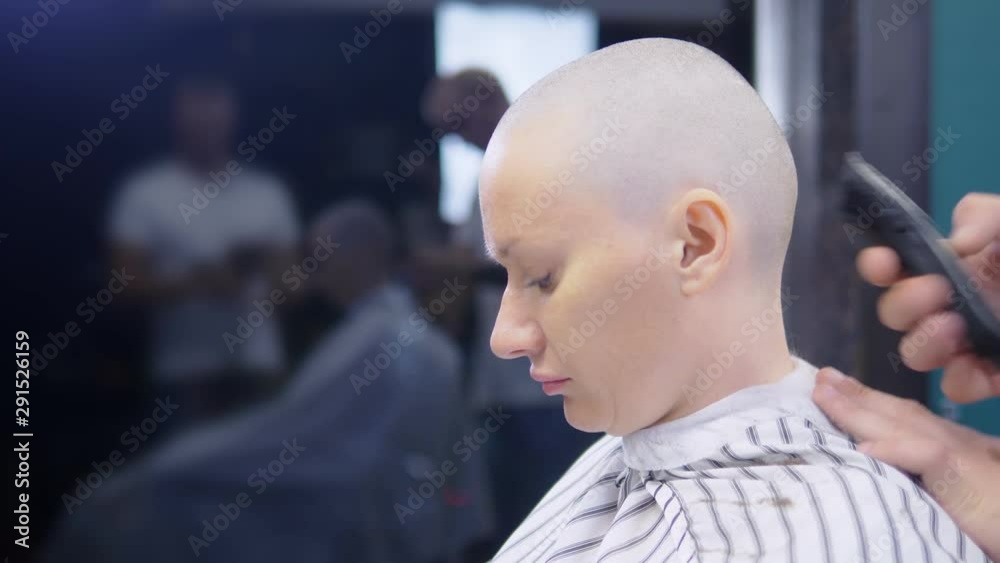 concept of hair loss after chemotherapy. the hairdresser shaves the ...