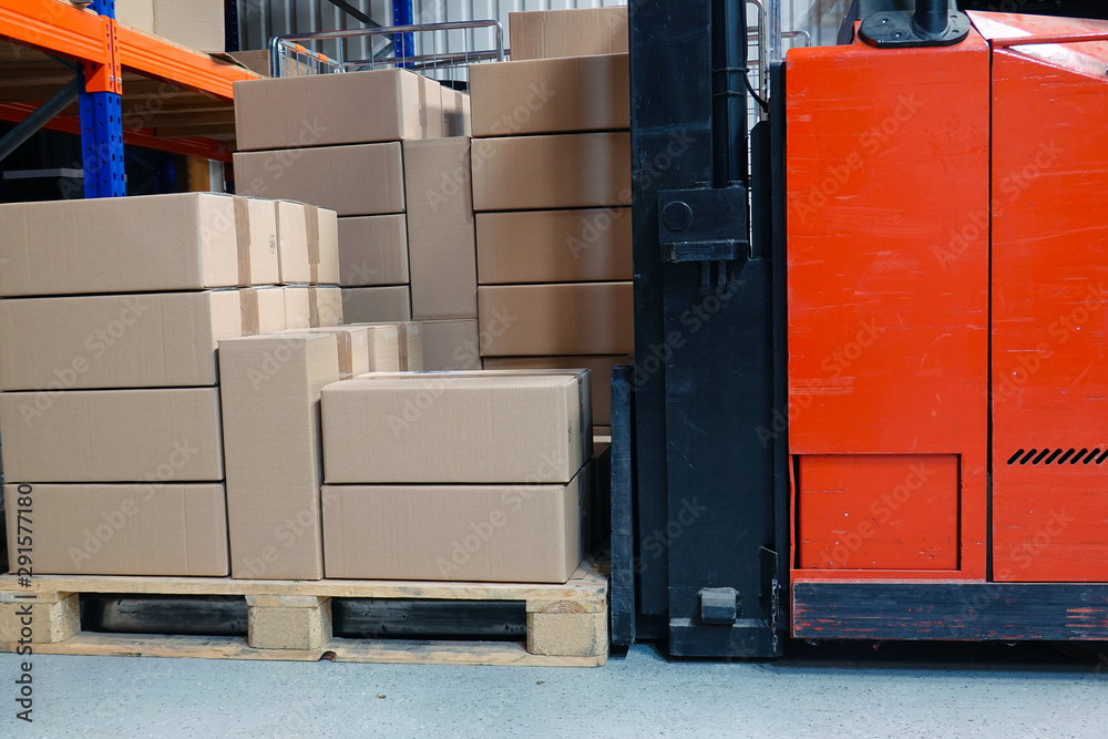 Cardboard boxes and forklift in the warehouse. Close up side view ...