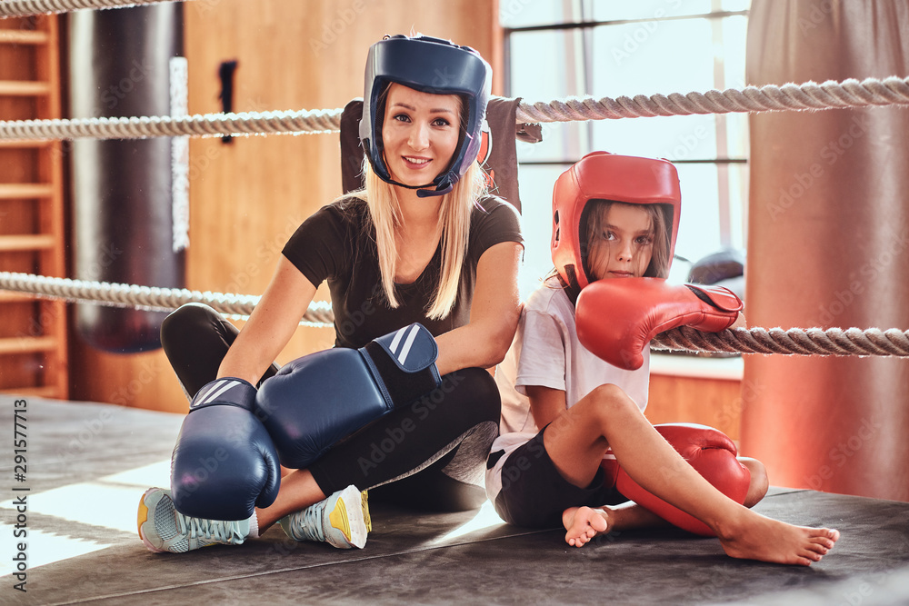 Young cute girl in helmet and her beautiful female boxing trainer are ...