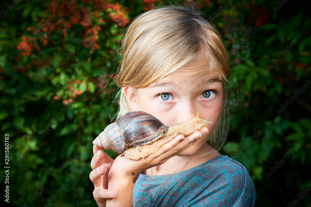 Portrait of preteen adorable child girl playing with her pet giant ...