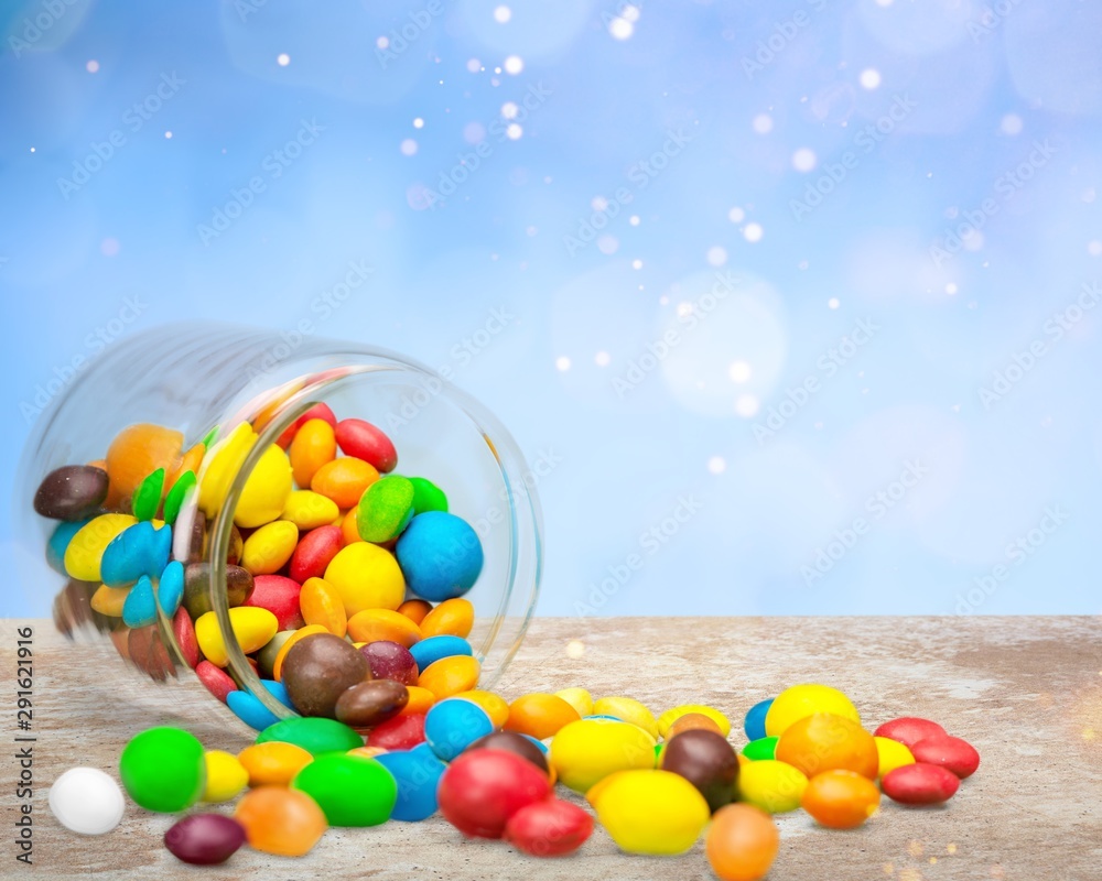 Colorful candies sweets falling out of a glass jar, composition ...