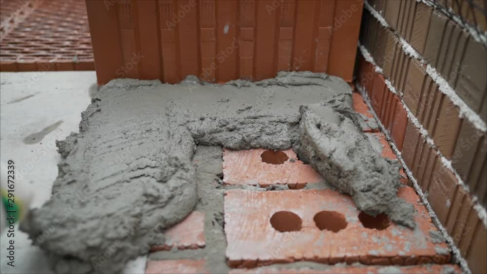 Builder smears a mortar under a brickBuilder's hands with putty knife ...