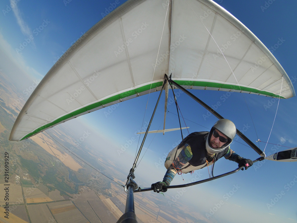 Pilot controls his hang glider wing on hign altitude. Stock Photo ...