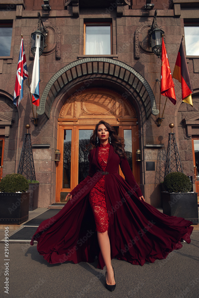 Young beautiful stunning woman in red luxury evening dress with flying ...