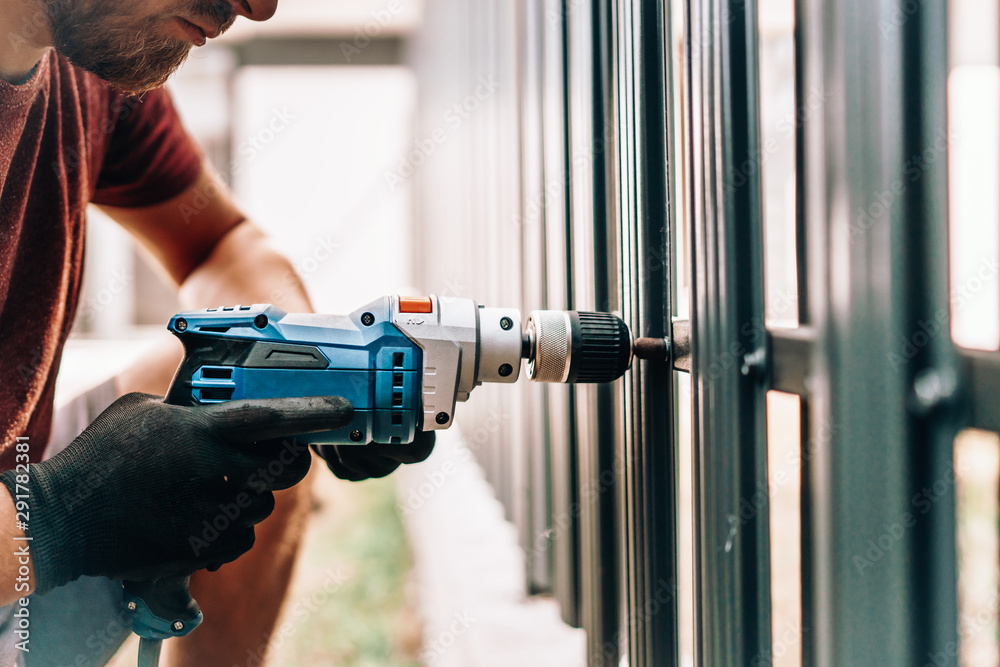 Man working with an electric screwdriver on the construction site Stock ...