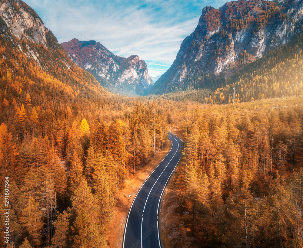 Aerial view of the mountain road in beautiful autumn forest at sunset ...