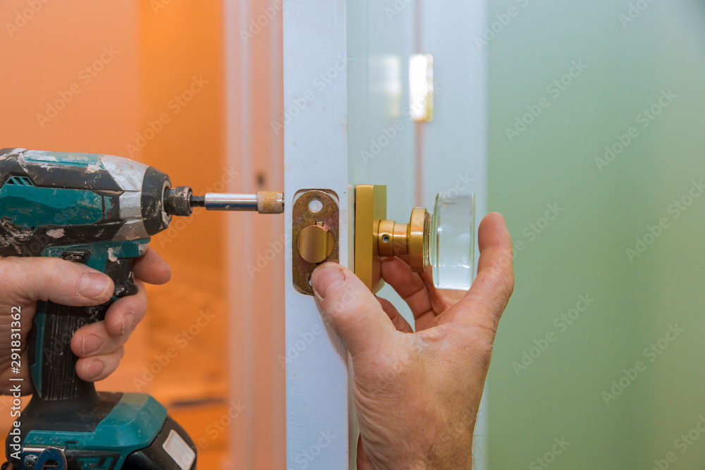 Closeup of a professional locksmith installing or new lock on a house ...
