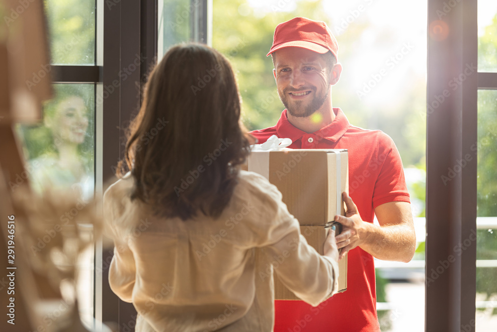 back view of woman receiving carton box from happy delivery man Stock ...