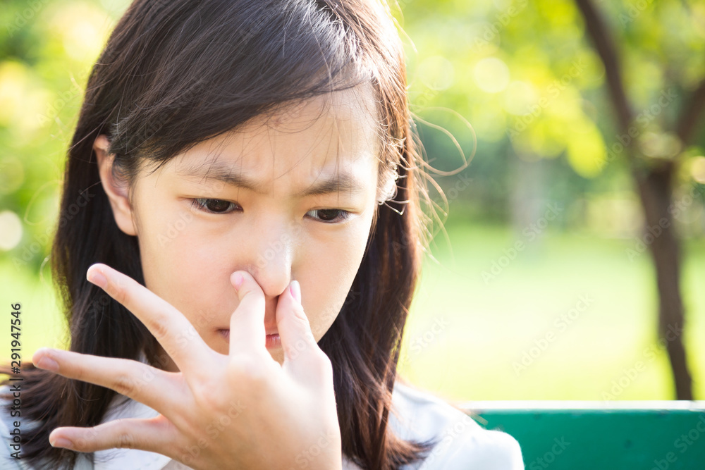 Closeup portrait beautiful child girl pinching nose with disgust on his ...