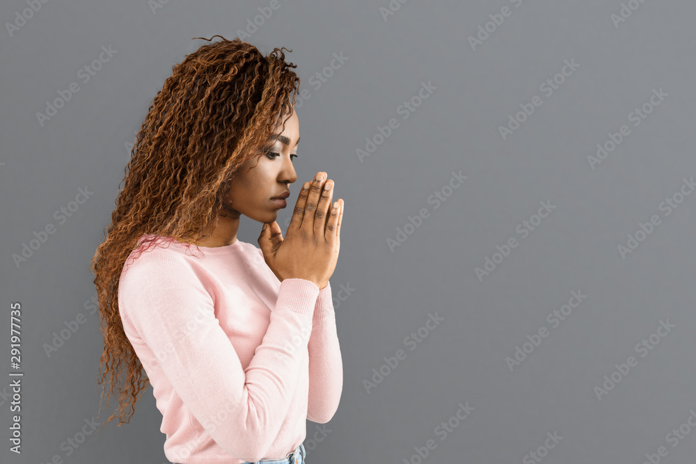 Desperate young girl praying over grey background Stock Photo | Adobe Stock