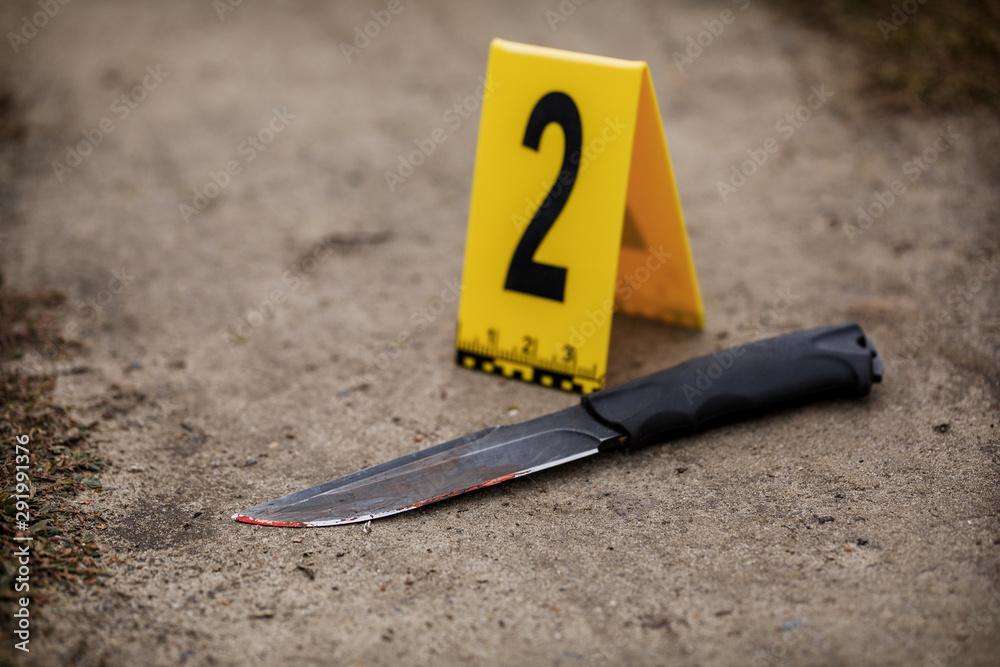 Crime scene investigation, bloody knife with crime markers on the ...