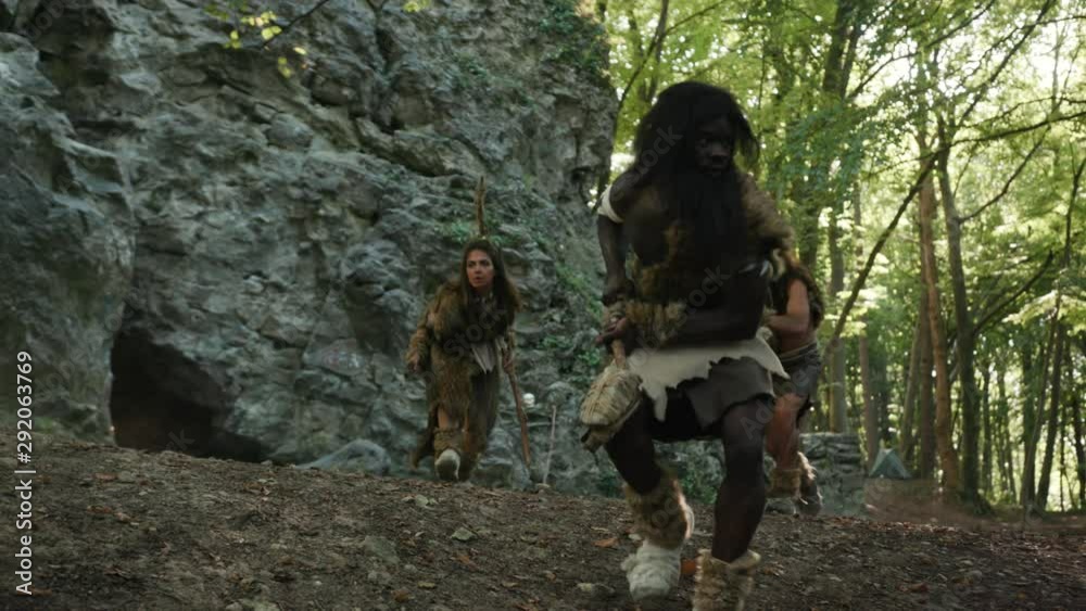 Primitive wild family of neanderthals hunting in the forest. African ...