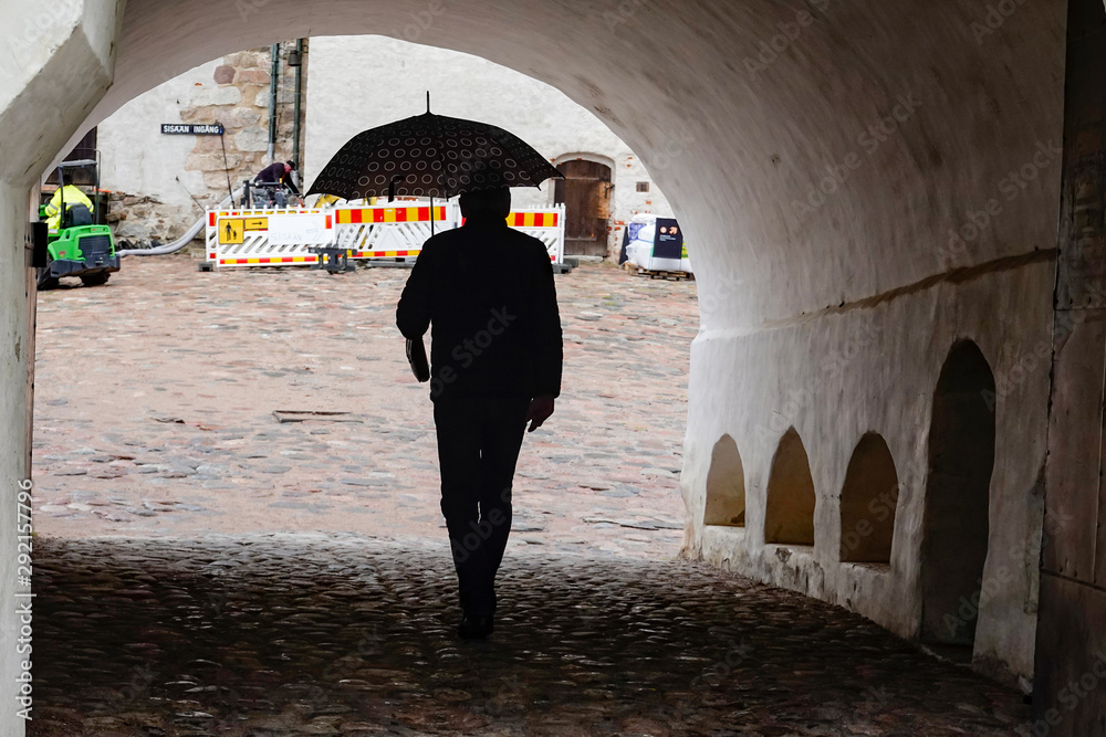 Turku, Finland A man with umbrella enters the main vaulted gate at the ...