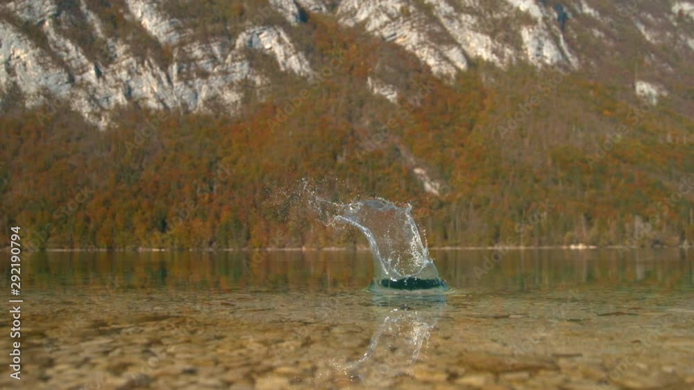 SLOW MOTION LOW ANGLE, CLOSE UP DOF: Cinematic shot of a rock falling ...