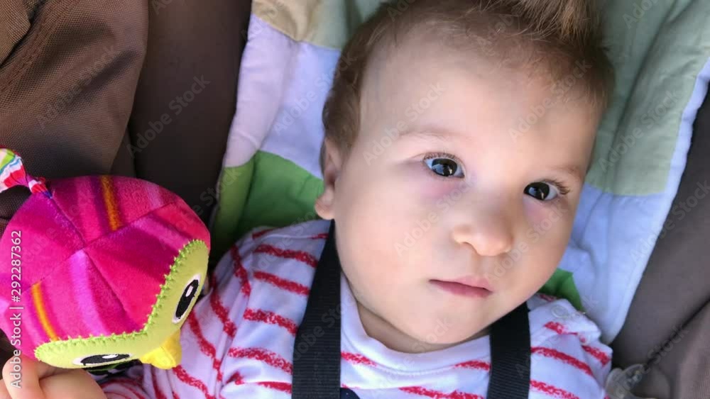 Vidéo Stock Cute baby with disability in a push chair with toy smiling ...