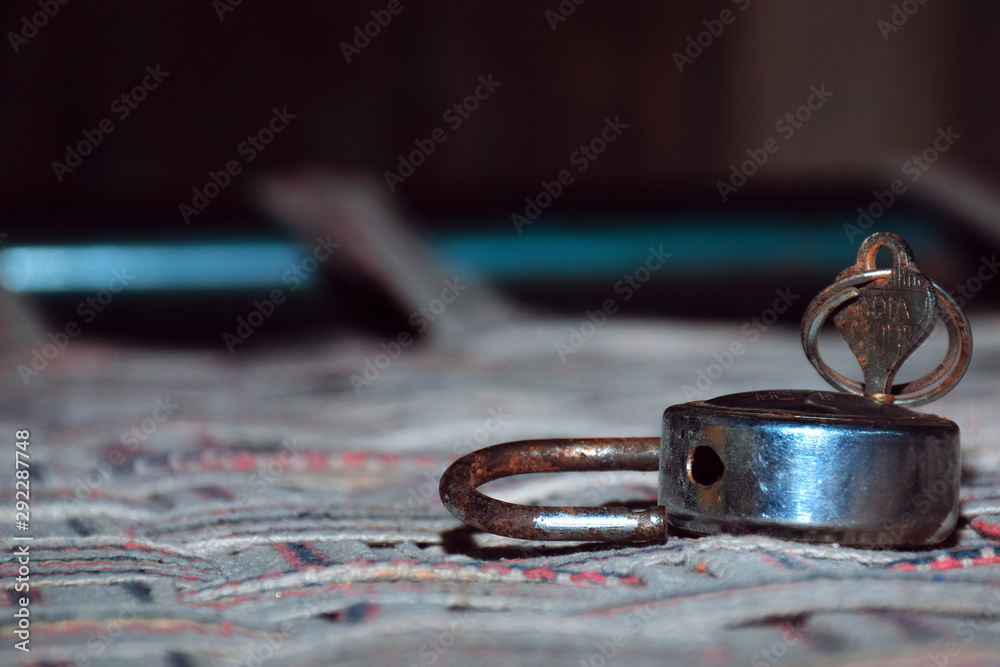 The old lock and key on abed of clothes with blur and black background ...