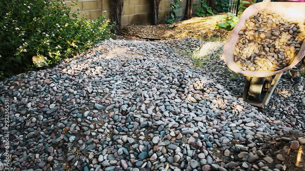 Mound of river rock with a newly planted, trellised garden in the ...