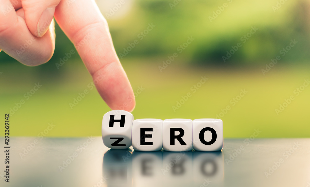 From zero to hero concept. Hand turns a dice and changes the word "zero ...