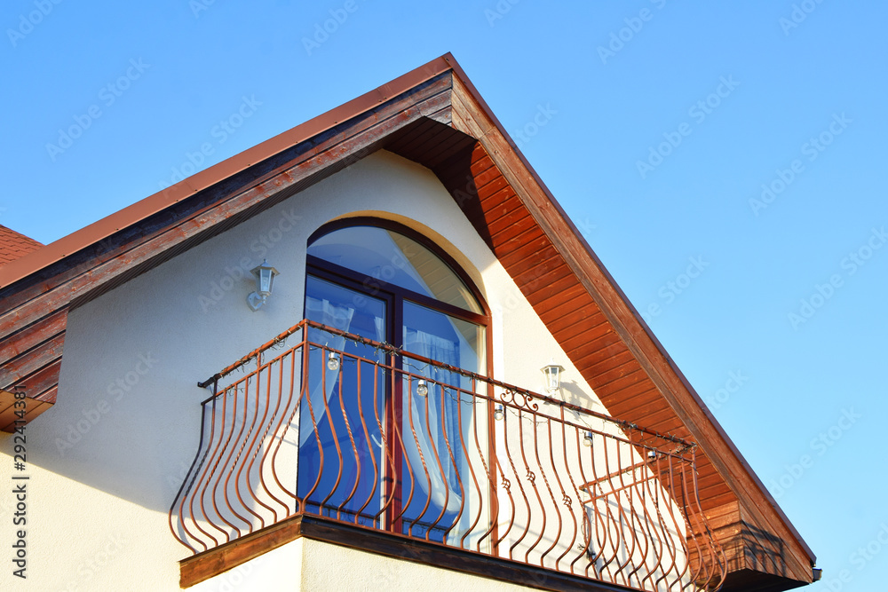 Part of light yellow house facade with metal balcony railing brown ...