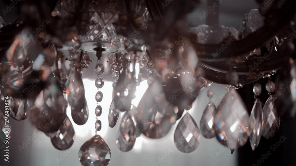 Abstract close-up pan across glass in crystal chandelier with sparkling ...