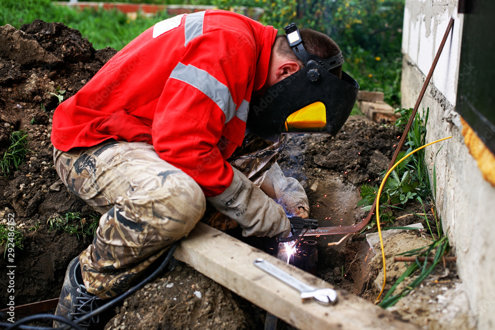 Man in welding mask performing weld construction. Welder constructing ...