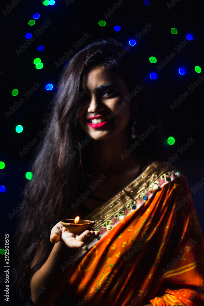 Young teenager girl celebrating diwali in Indian saree with diwali diya ...