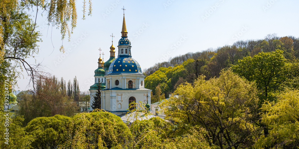 Foto de A view of the Vydubitsky monastery with golden and blue roofs ...