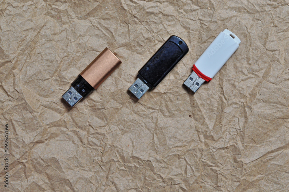 Foto de Three usb flash drives, white, black and bronze are in ...