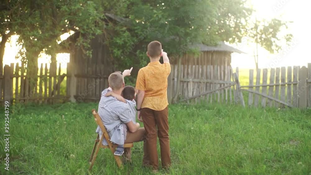 Three brothers hugging each other. Three little boys looking up at the ...