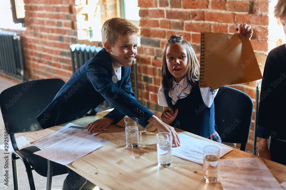 beautiful little girl showing her ideas to her friend, showing ...