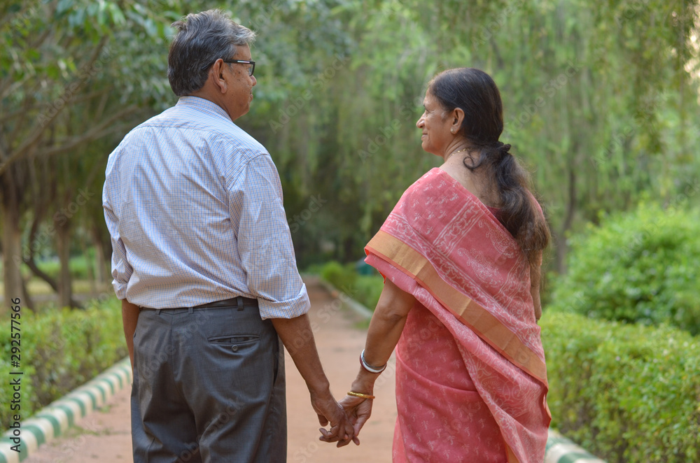 Shot from the back happy looking retired senior Indian man and woman ...