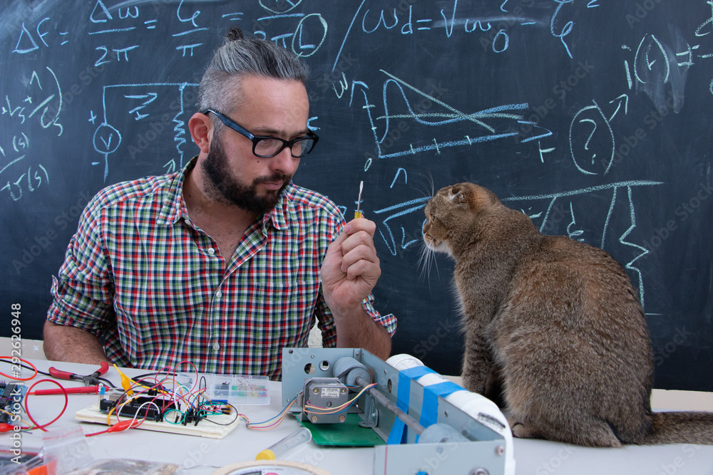 Hipster guy working on arduino project getting visited by cute Scottish ...